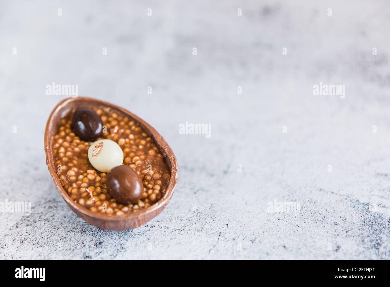 Half a chocolate egg filled with popped rice and small shocolade eggs ...