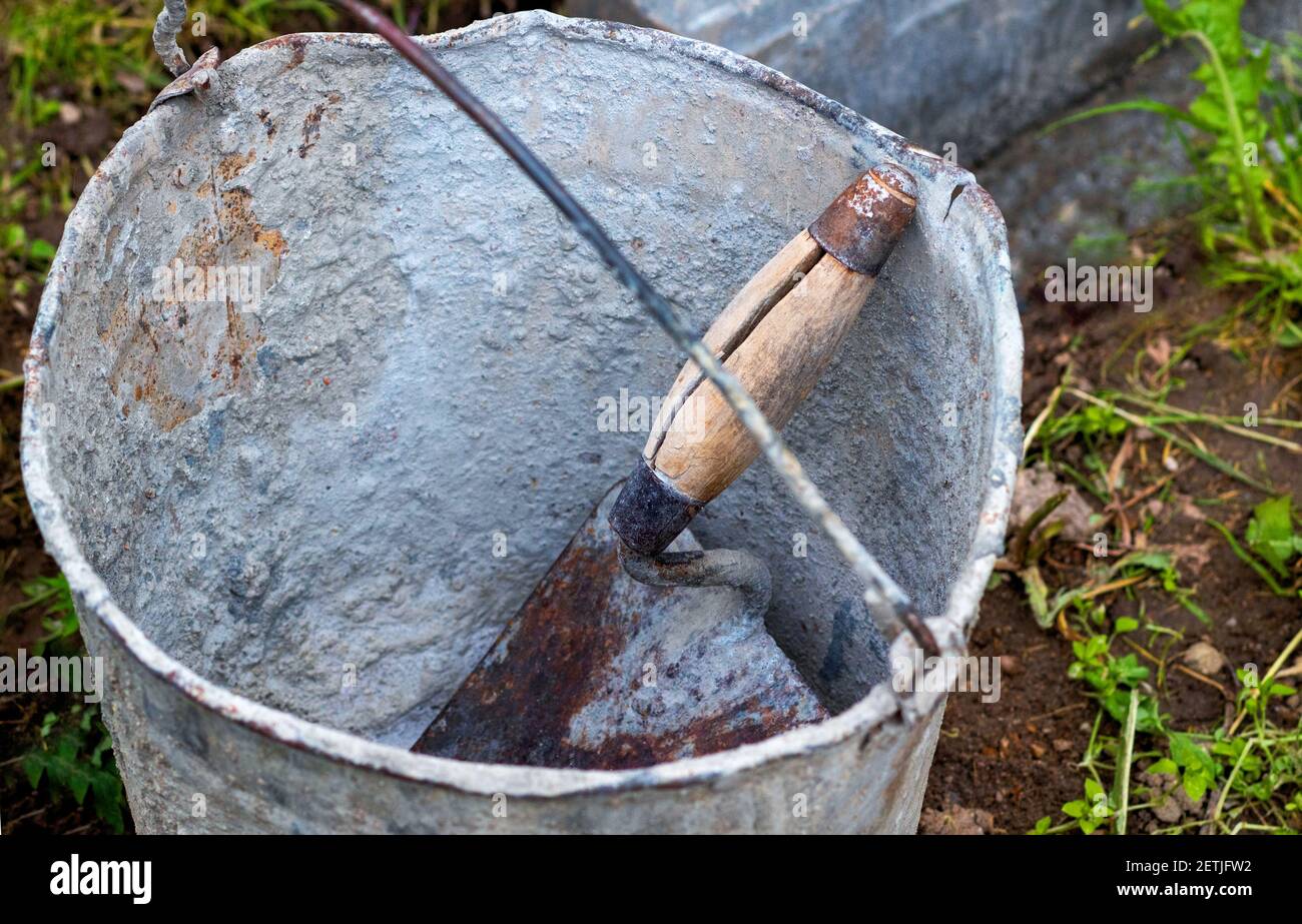 The use of cement for construction. Knead the cement in a bucket. The ...