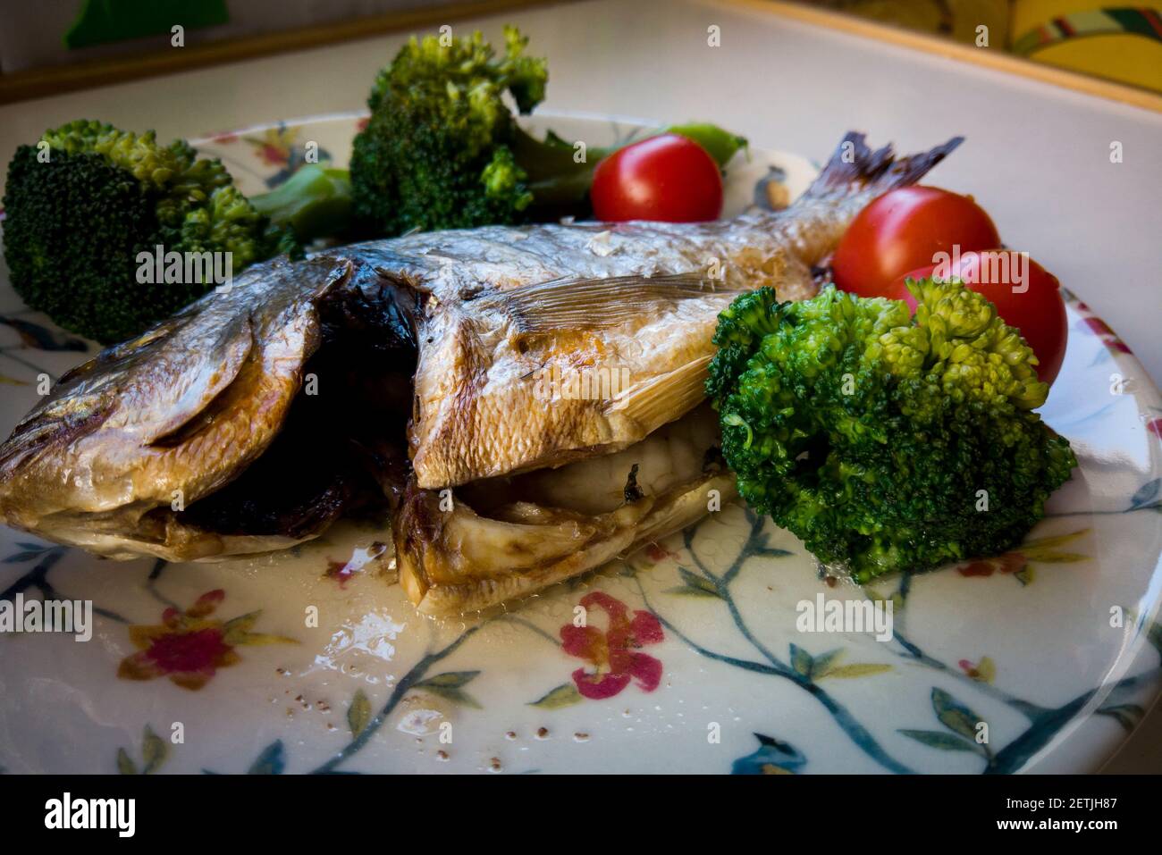 gilt-head bream fish grilled with tomato and broccoli Stock Photo - Alamy