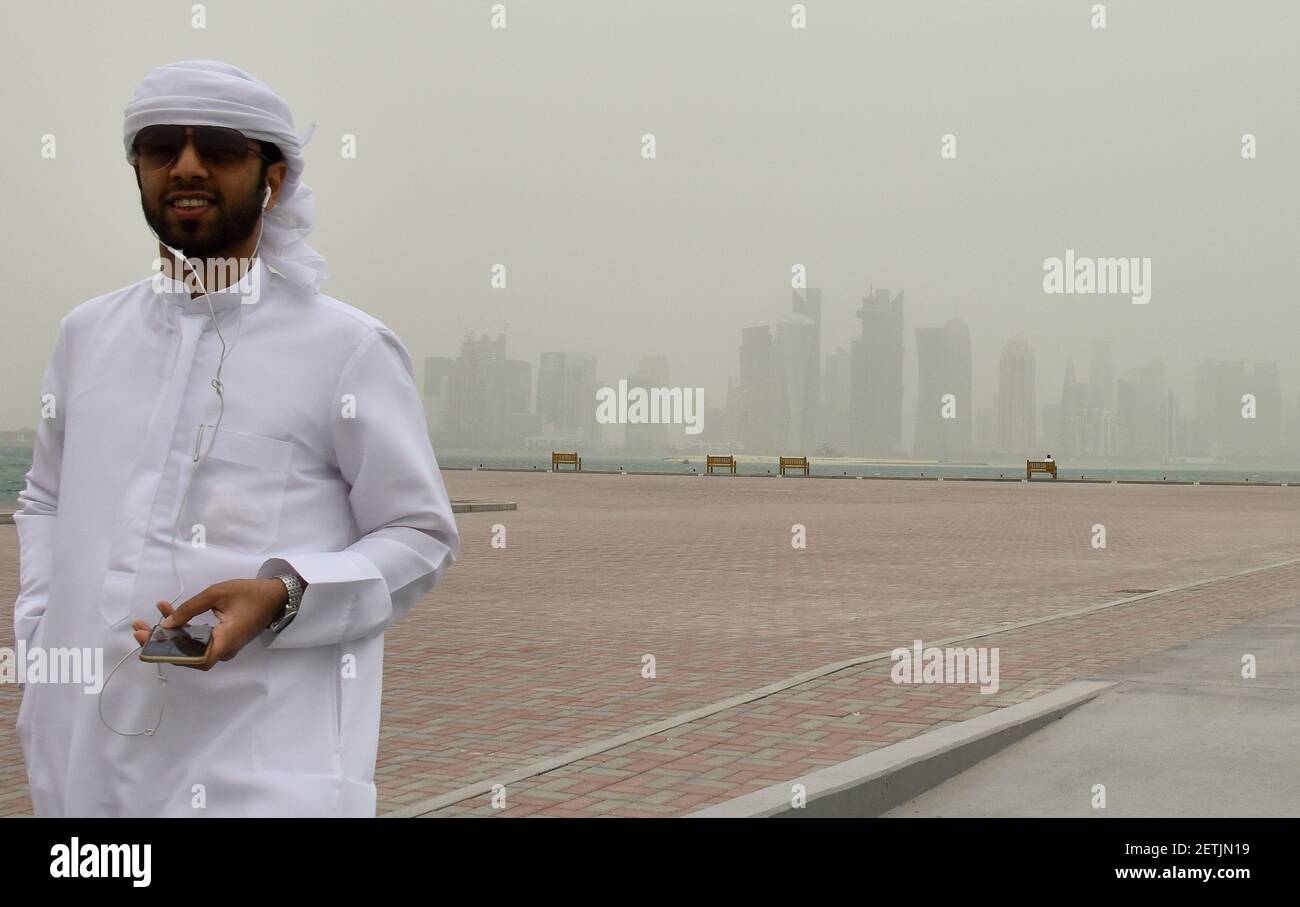 A Qatari man waking at doha corniche in low visible dust storm that hit ...