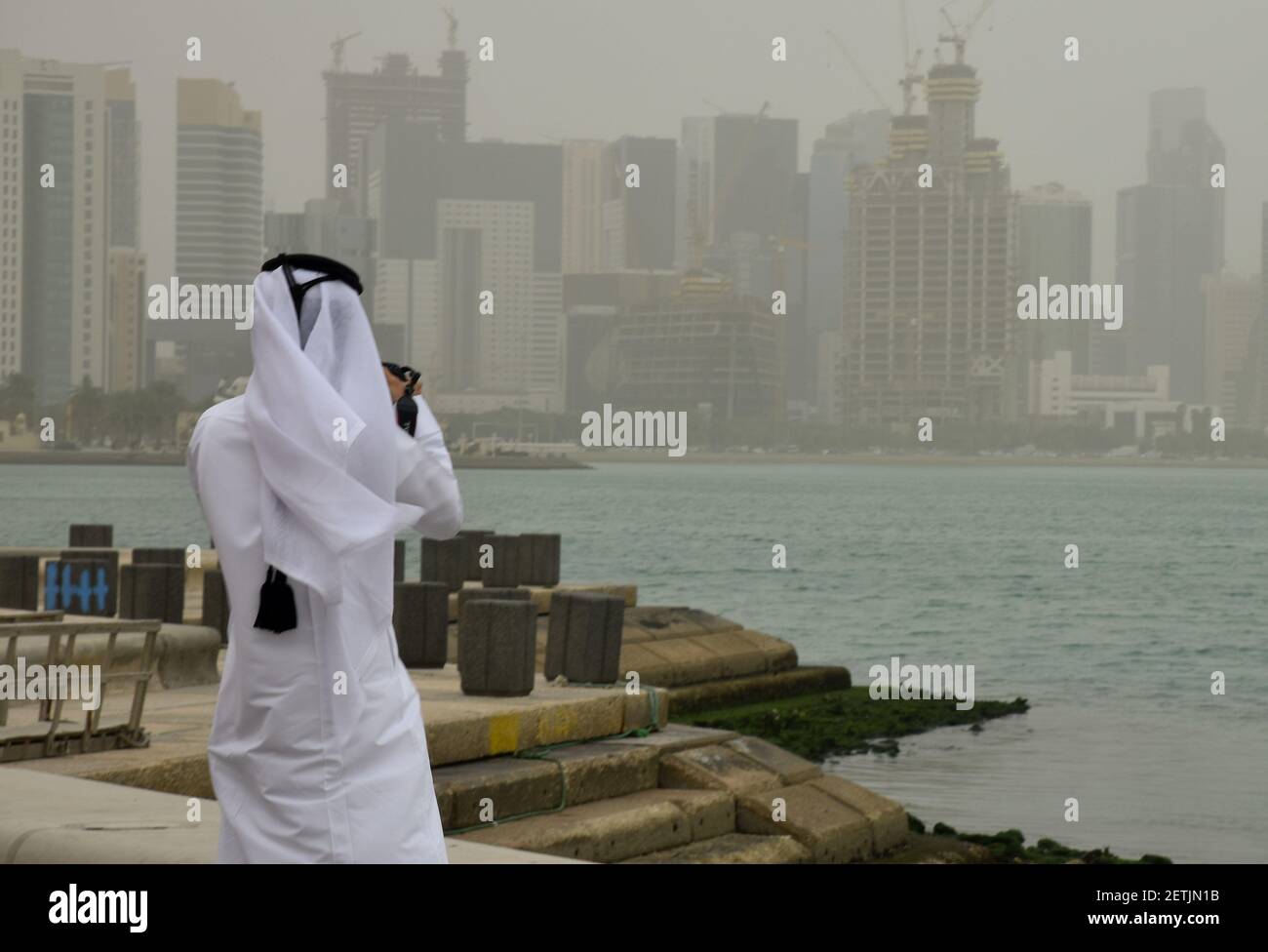 A Qatari man takes photos of the sand and dust storm that hit doha ...