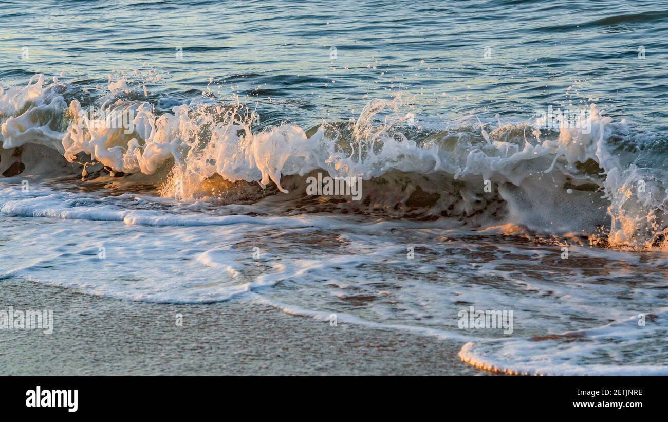 Splashing waves on the beach Stock Photo - Alamy