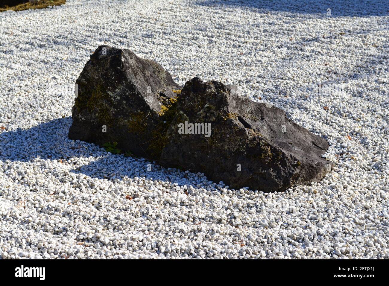 A huge isolated rock surrounded by white ground stones Stock Photo - Alamy