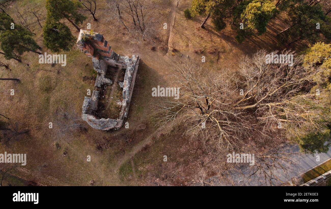 An aerial top view of a ruined abandoned building in a dense forest ...