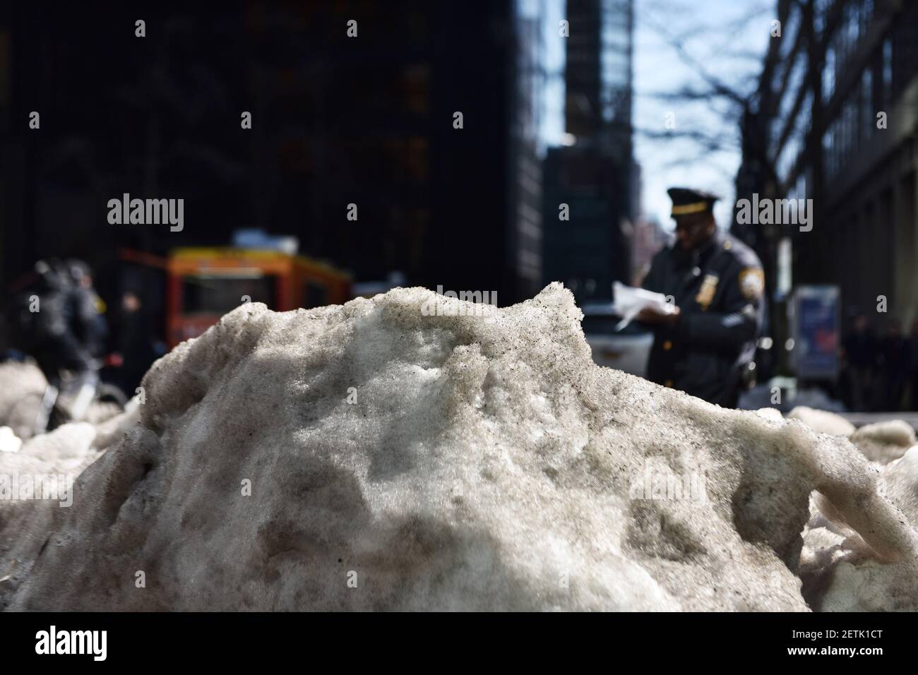 A NYPD Traffic officer looks at paperwork as he stands behind a pile of ...