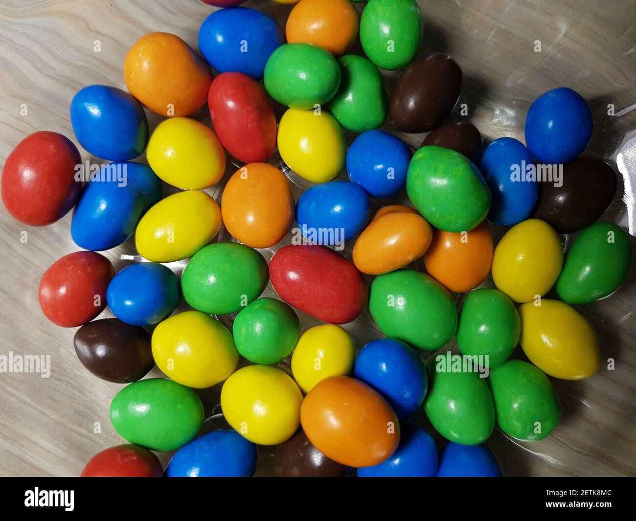 Multicolored chocolate-covered nuts in a transparent plate Stock Photo ...