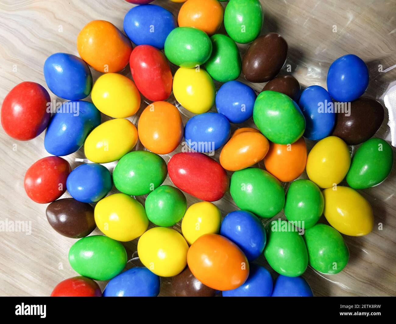 Multicolored chocolate-covered nuts in a transparent plate Stock Photo ...