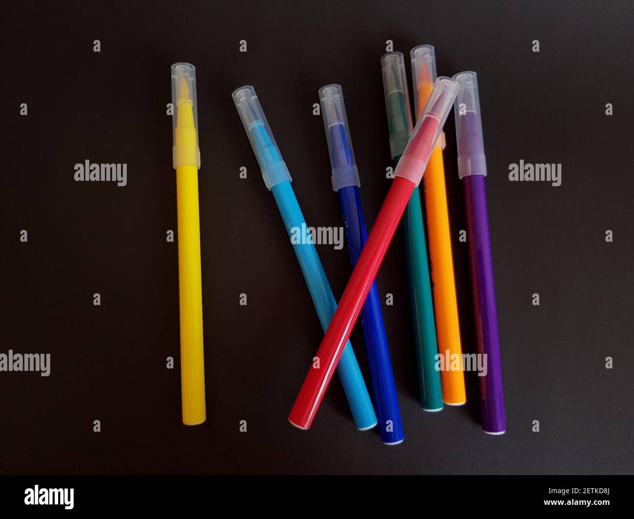 Multi-colored markers for drawing. Markers on a black isolated ...