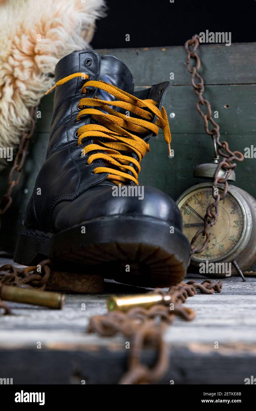 Leather boot with rusted chains and bullet shells with military gas ...
