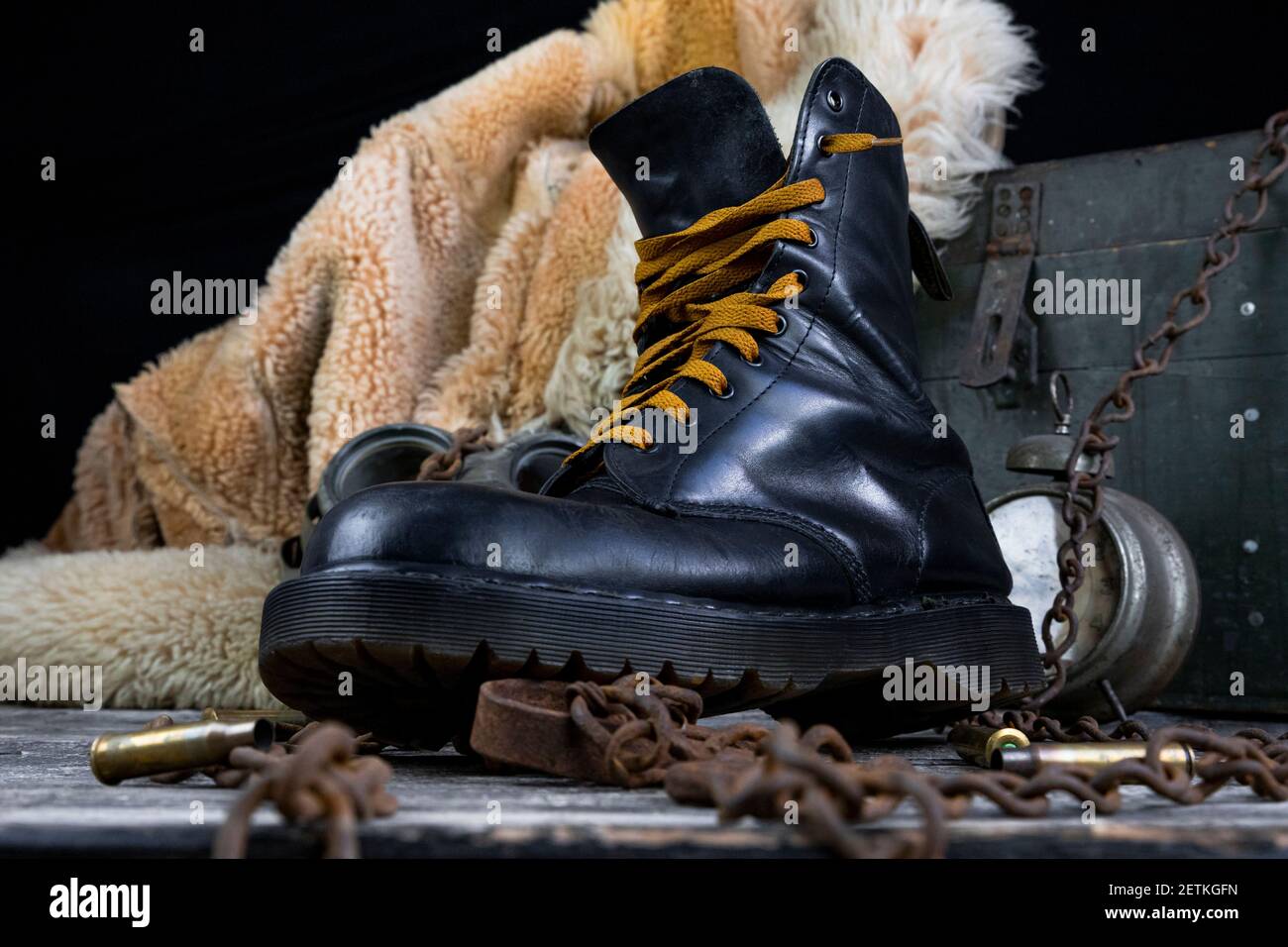Leather boot with rusted chains and bullet shells with military gas ...