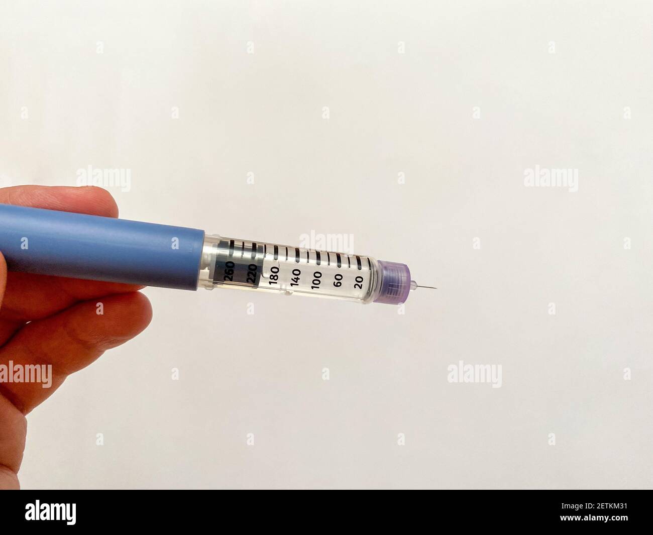 Insulin syringe-pen in hand on a white isolated background. Insulin for ...
