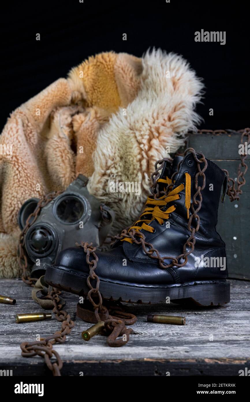 Leather boot with rusted chains and bullet shells with military gas ...