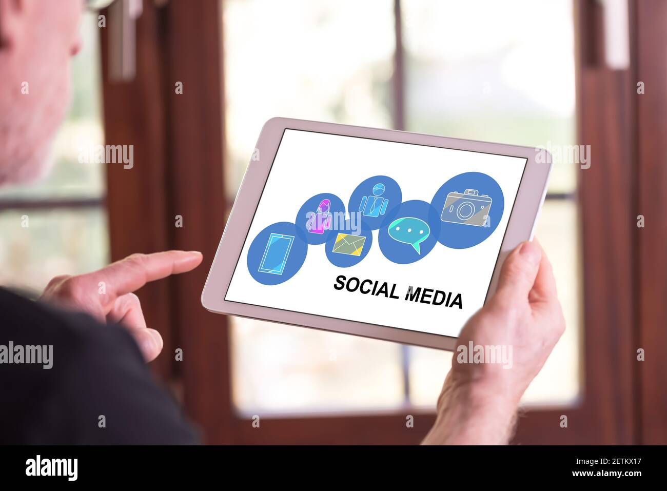 Man holding a tablet showing social media concept Stock Photo - Alamy