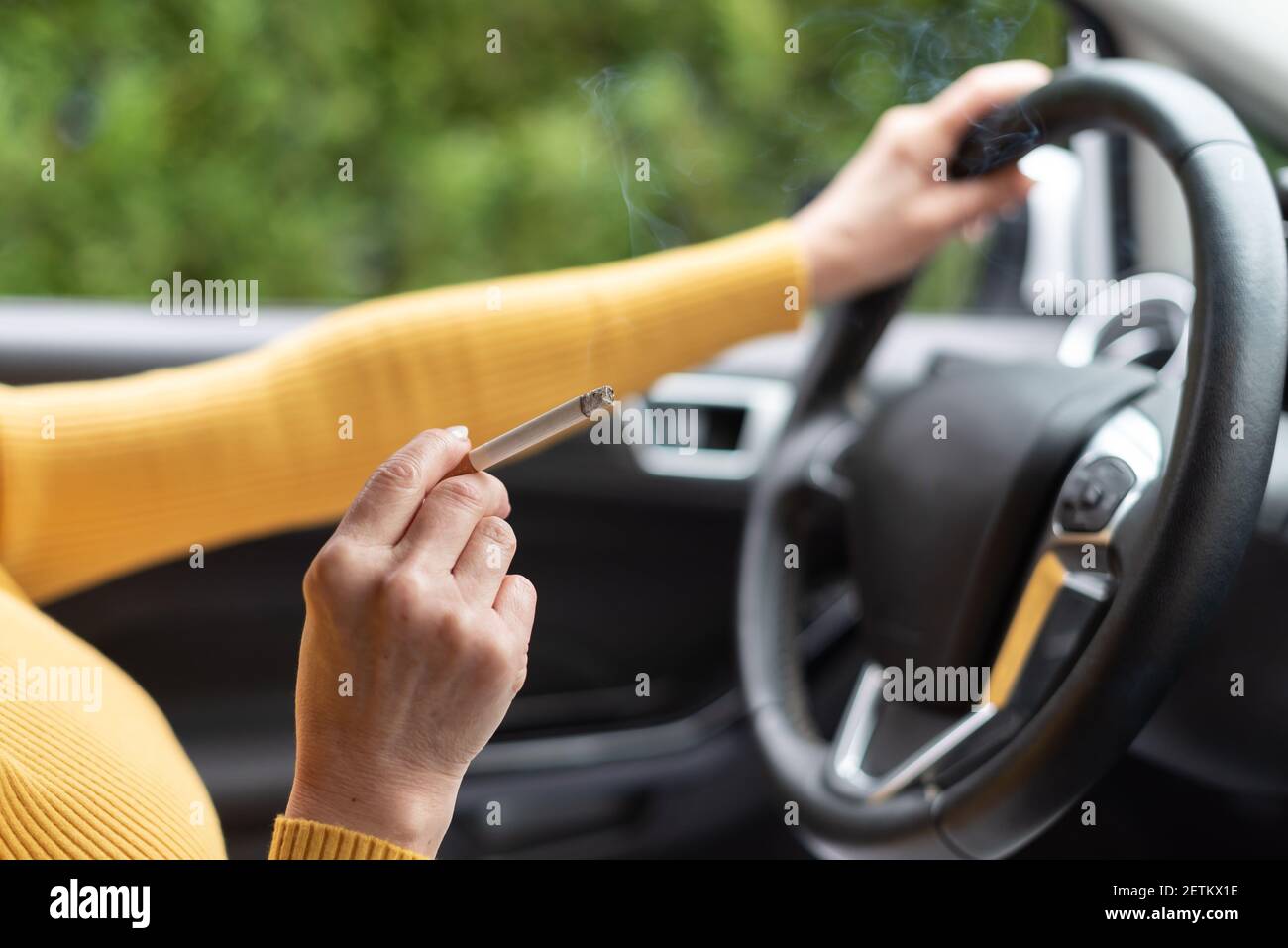 Woman smoking a cigarette while driving Stock Photo - Alamy