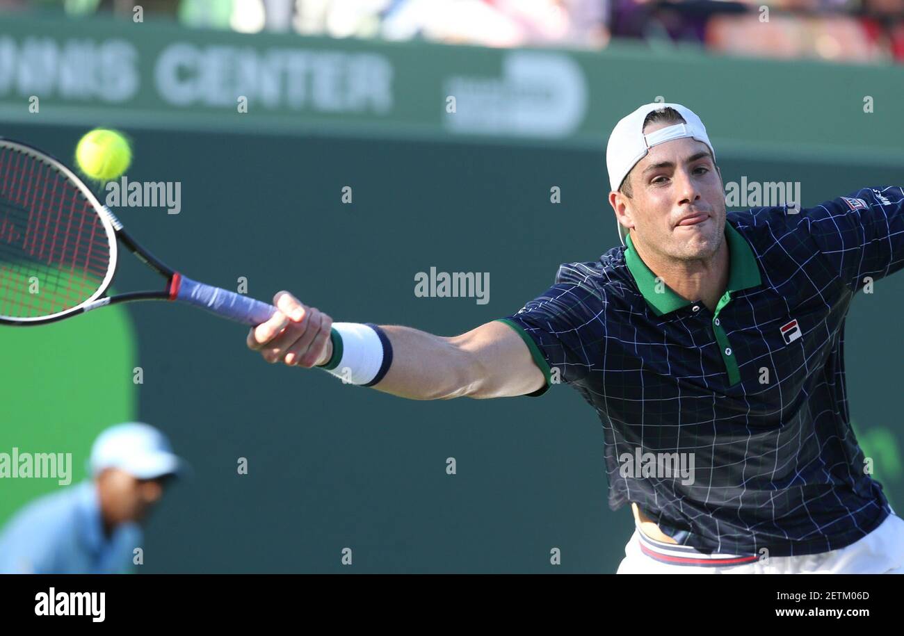 John Isner returns a ball hit by Alexander Zverev at the Miami Open on ...