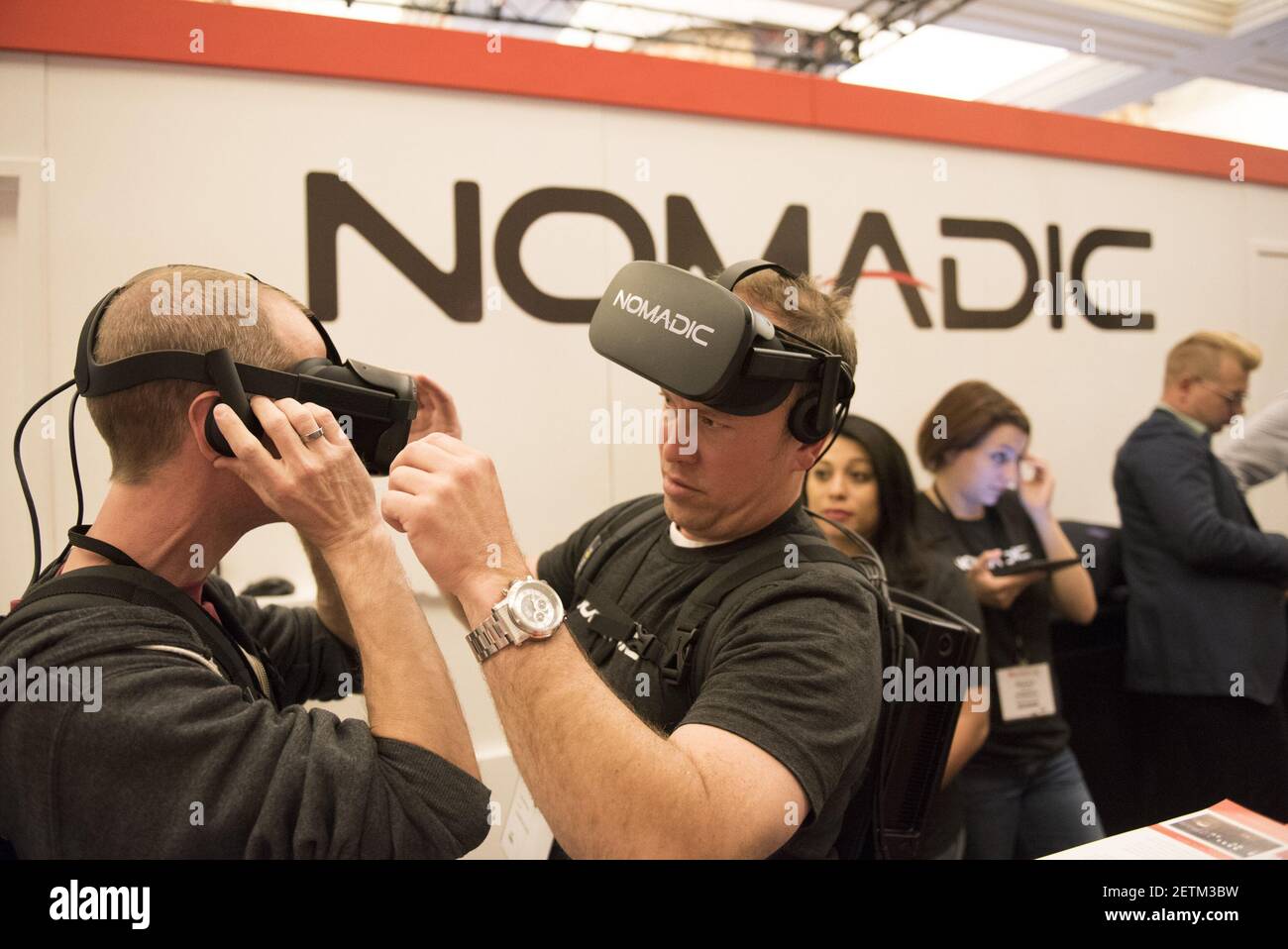 Scott Binnings, second from left, assists an attendee by putting on a ...