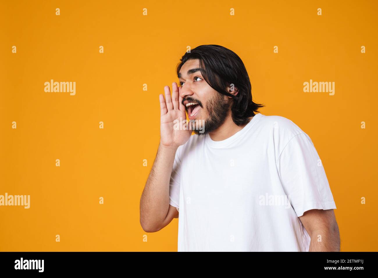 Angry indian man shouting his message isolated over yellow background ...