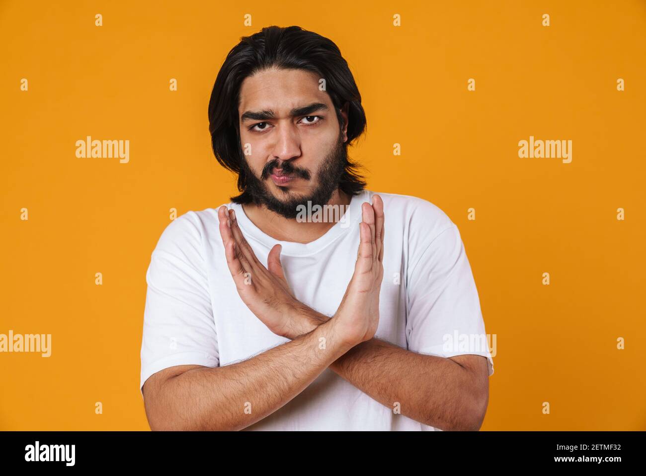 Upset young indian man showing denial gesture isolated over yellow ...