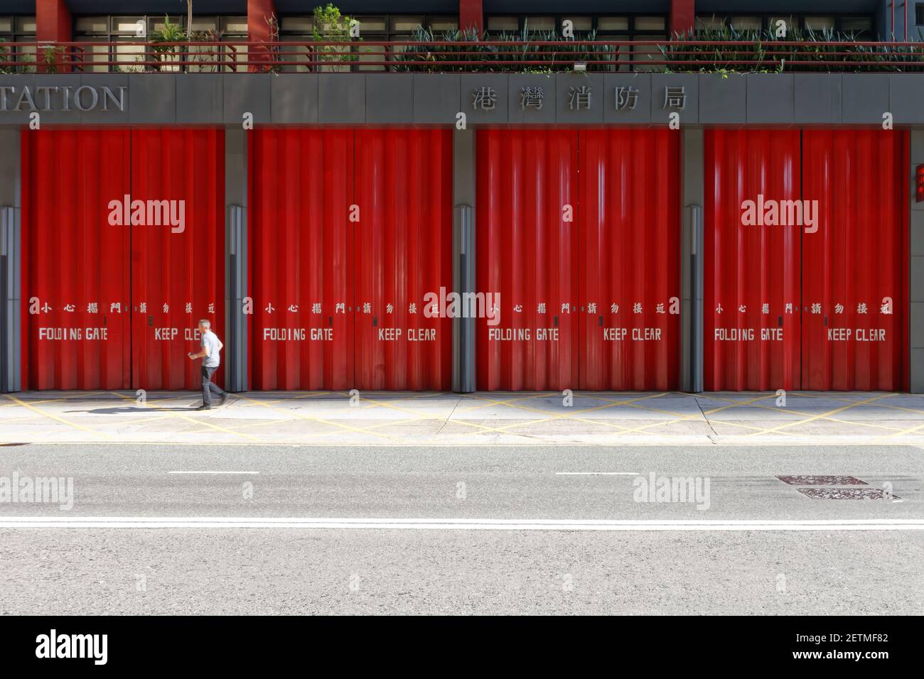 Red gates of fire service station with a passing male Stock Photo - Alamy
