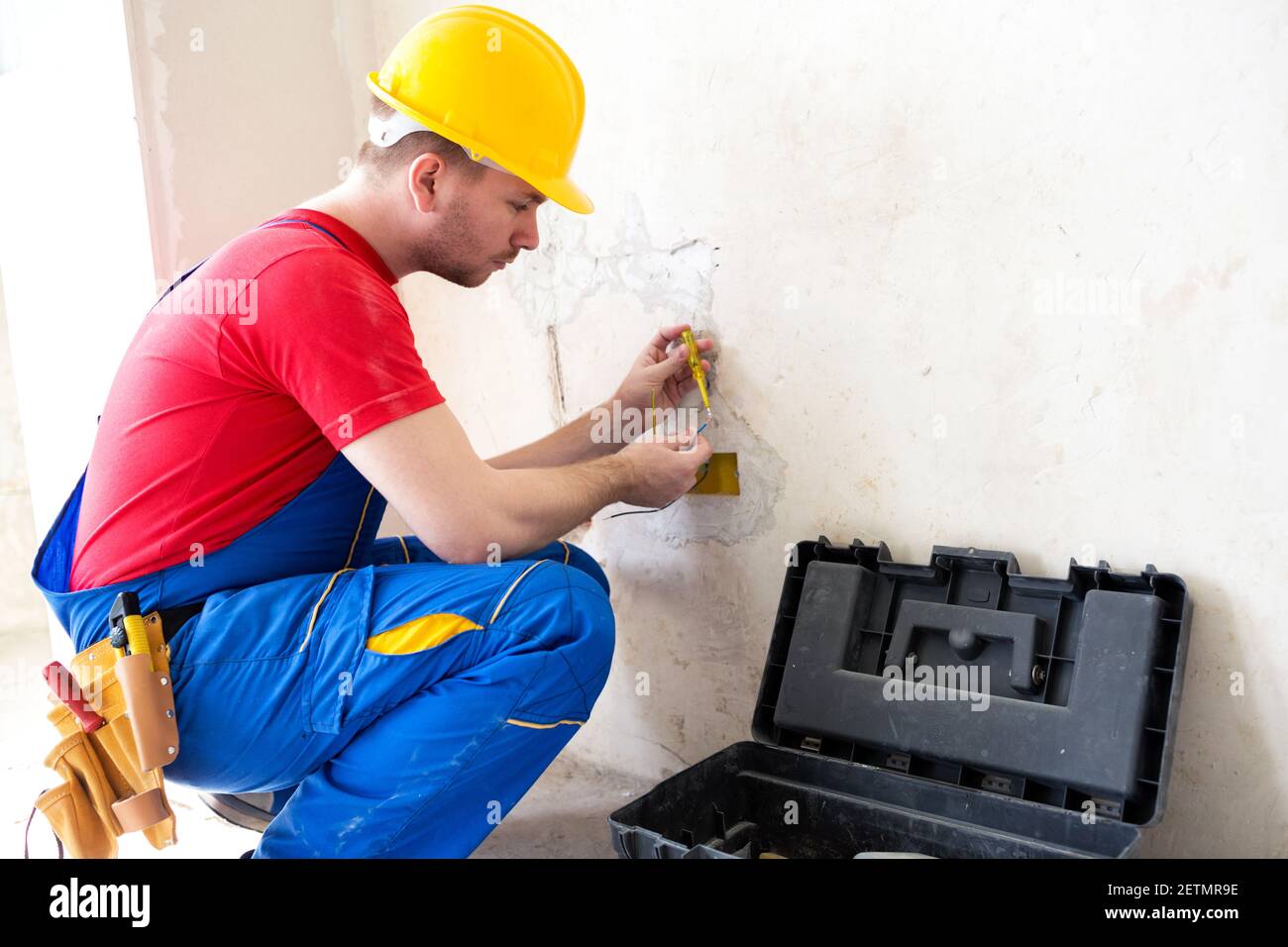 Electrician checking the voltage level in wall socket cables Stock ...
