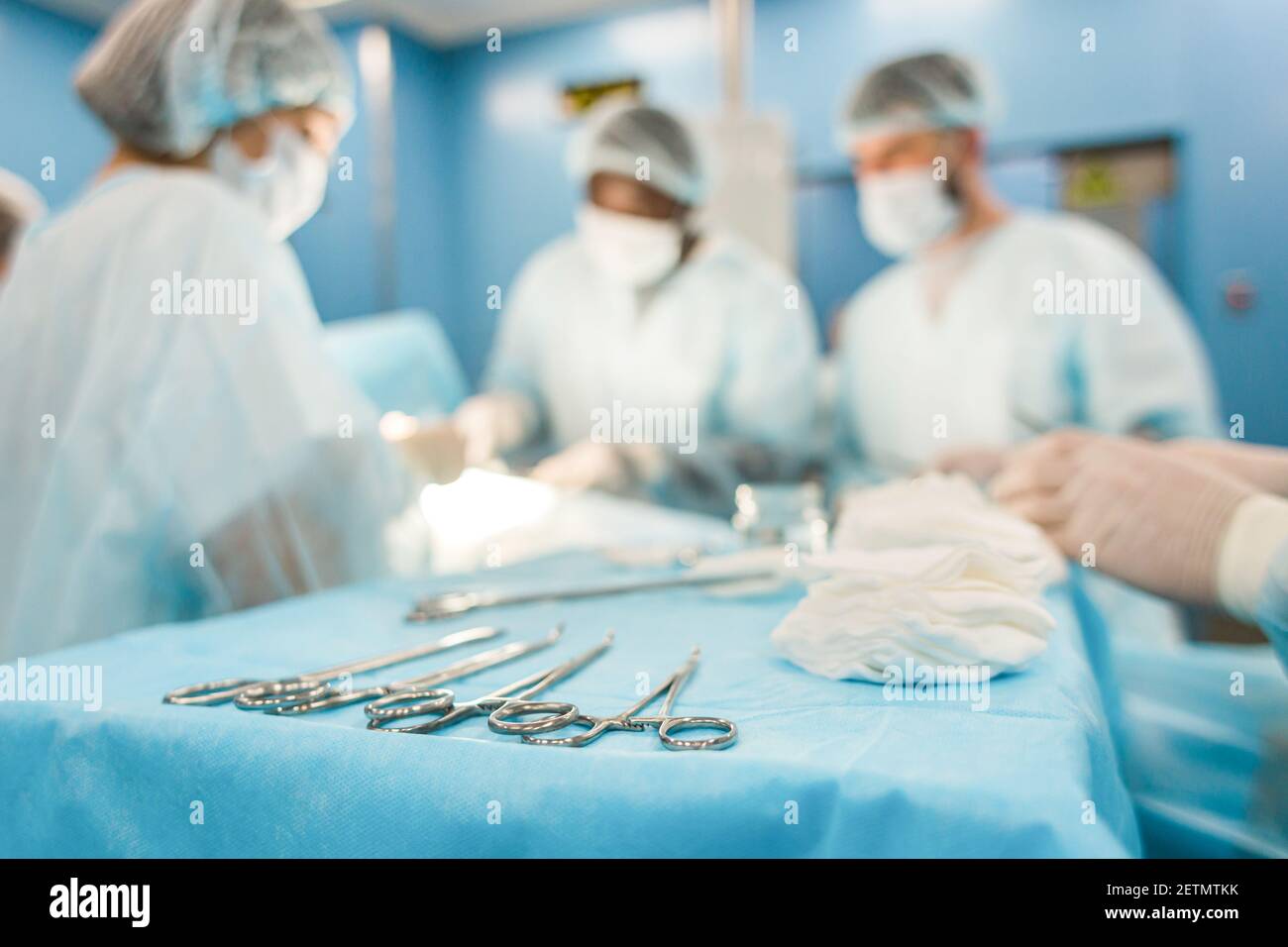 Tools for the operation in the foreground and a team of surgeons in the ...