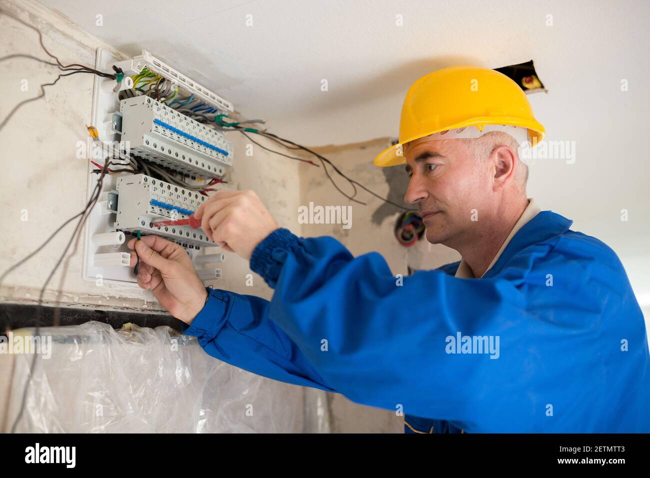 Senior electrotechnician connecting wiring system and completing the ...
