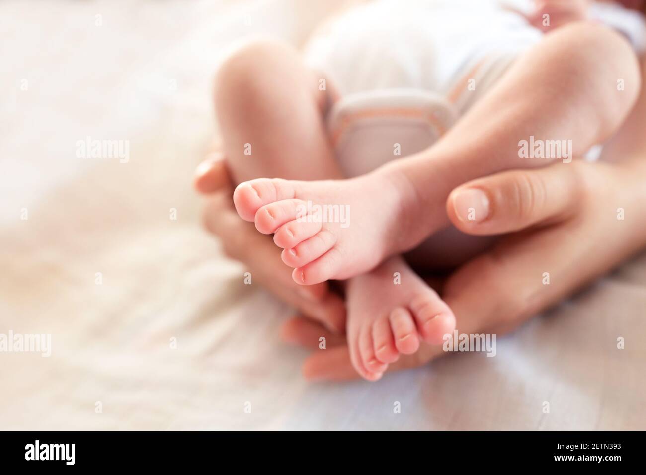 Soft baby skin and gentle hands of her mother holding the child with ...