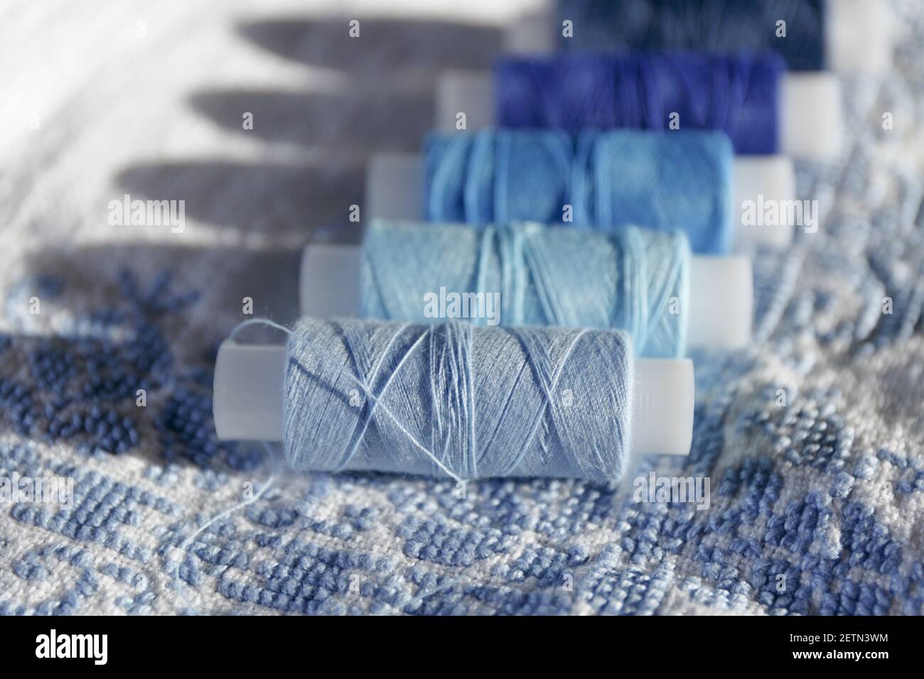 Blue threads. Set of sewing thread coils. Close-up of several bobbins ...
