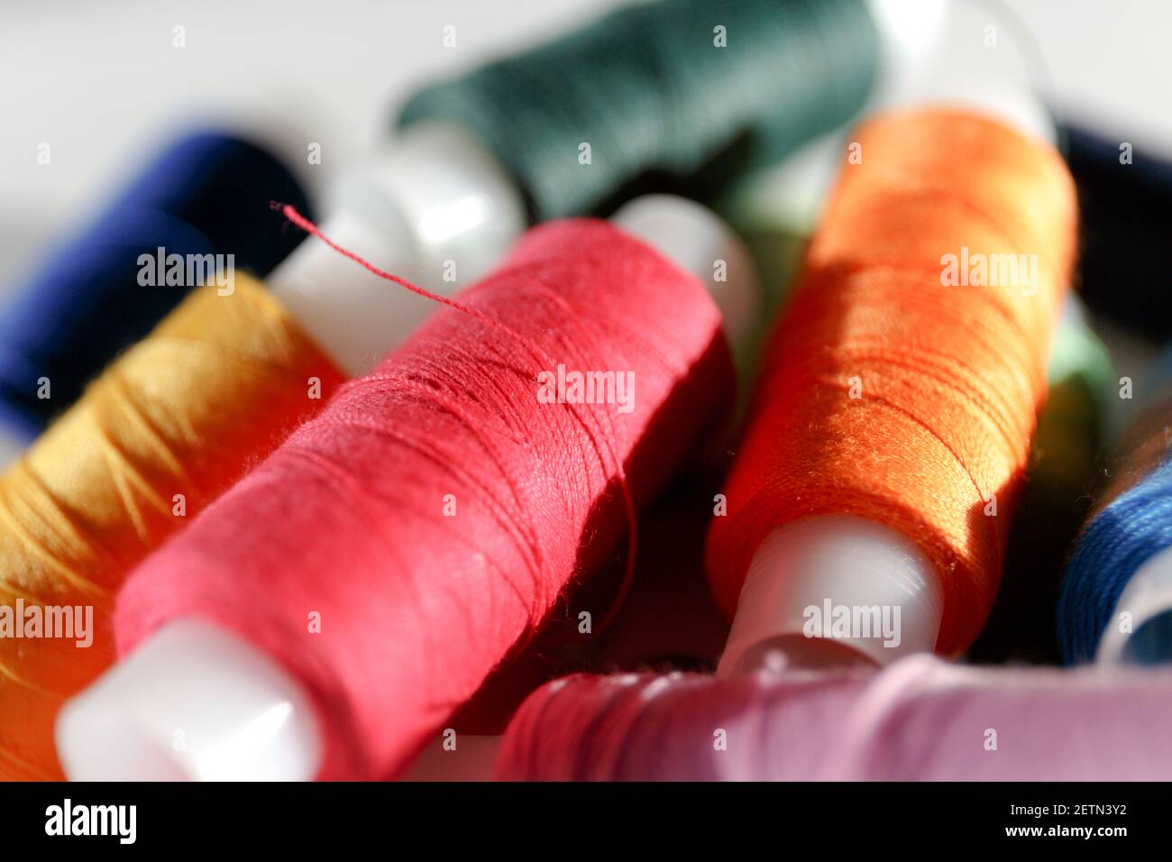 Color thread. Plastic reels with colorful threads close-up. Red and ...