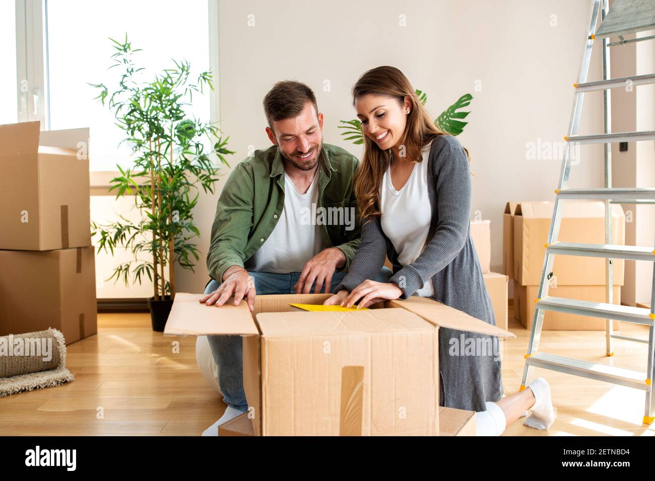Happy couple unpacking boxes in their new apartment and smiling Stock ...