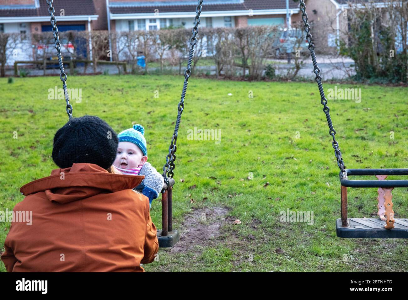 Caucasian Baby boy on the swing with mother in winter Stock Photo - Alamy