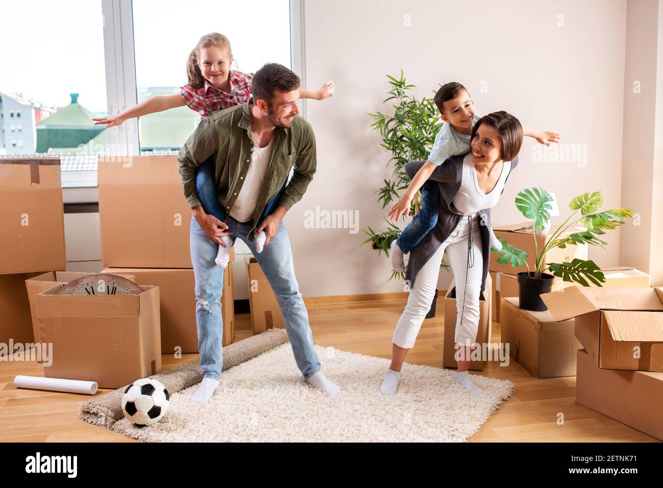 Young couple with their children moving in a new home and being happy ...