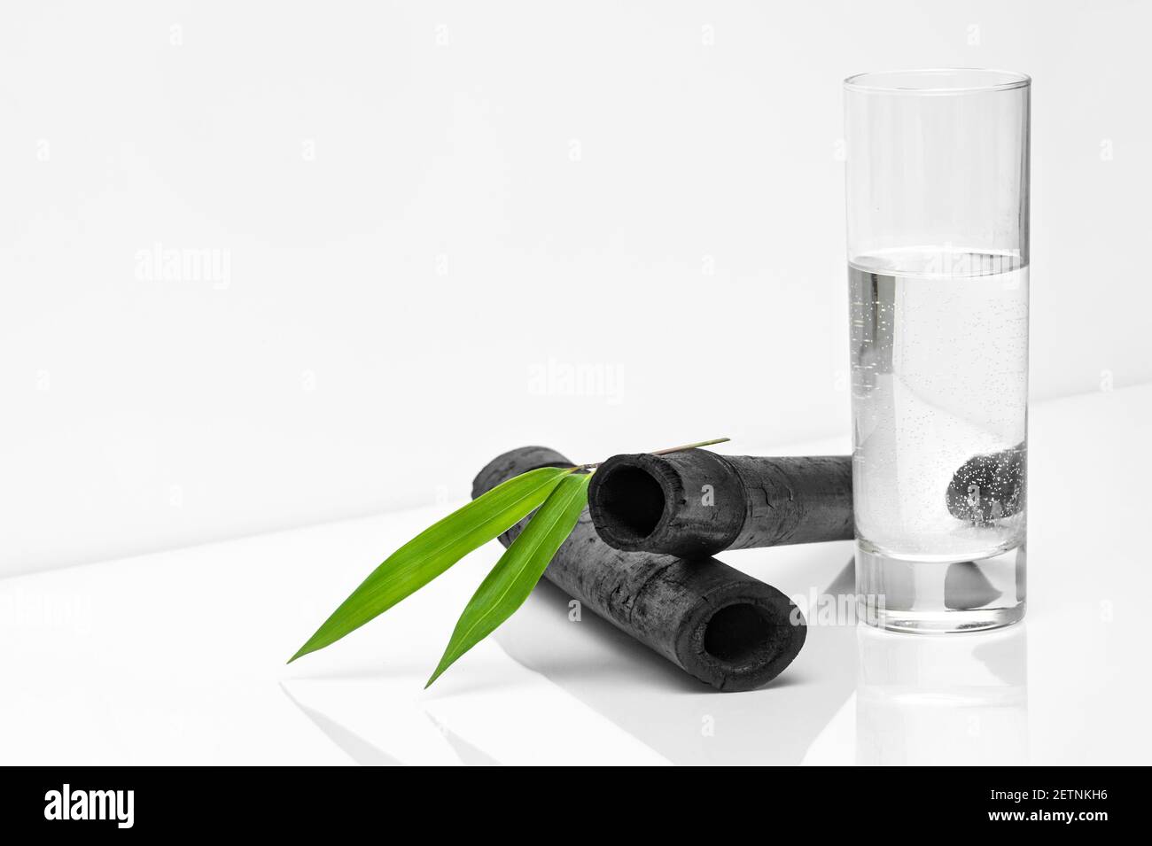 Bamboo charcoal water filter sticks, green leaf and glass of water ...