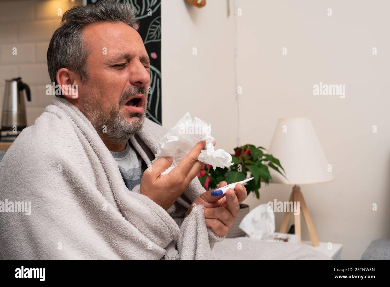 Adult man feeling unwell with cold influenza covid19 symptoms sneezing ...