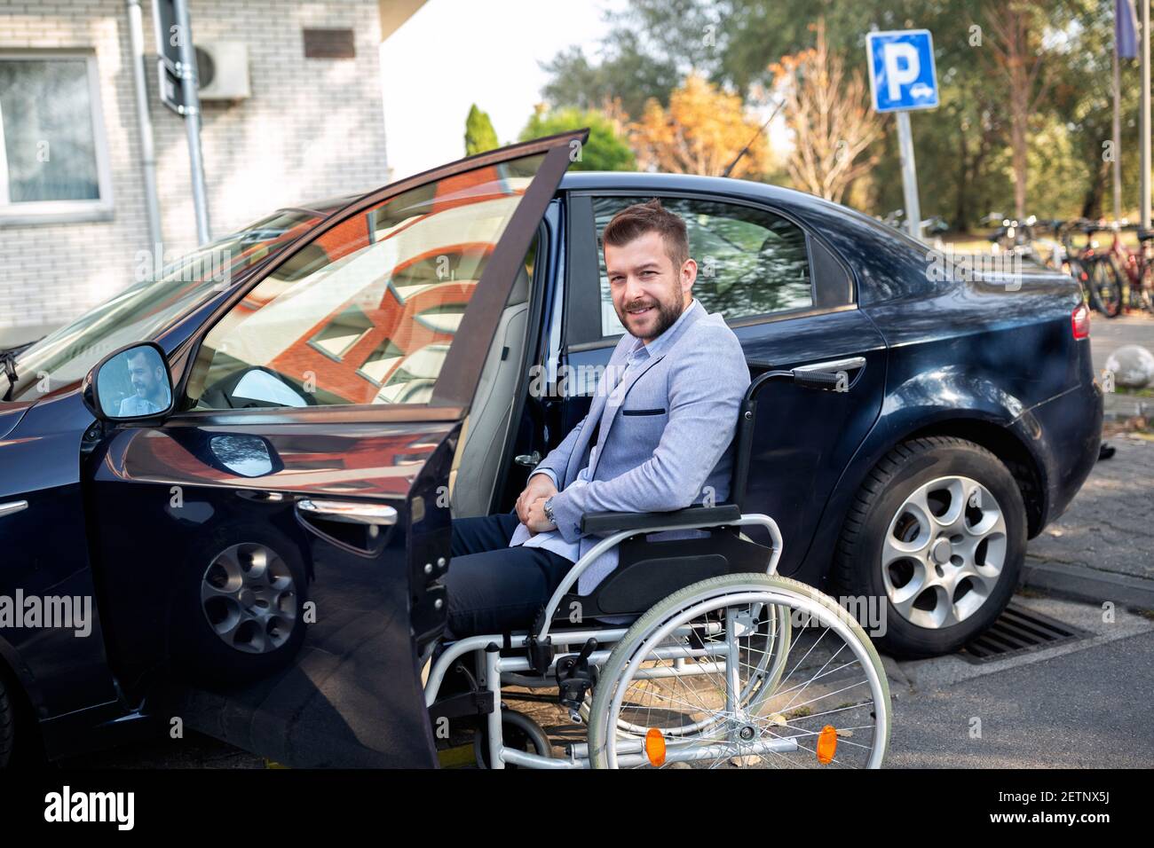 Handicapped young man reaching for his car on the parking lot Stock ...