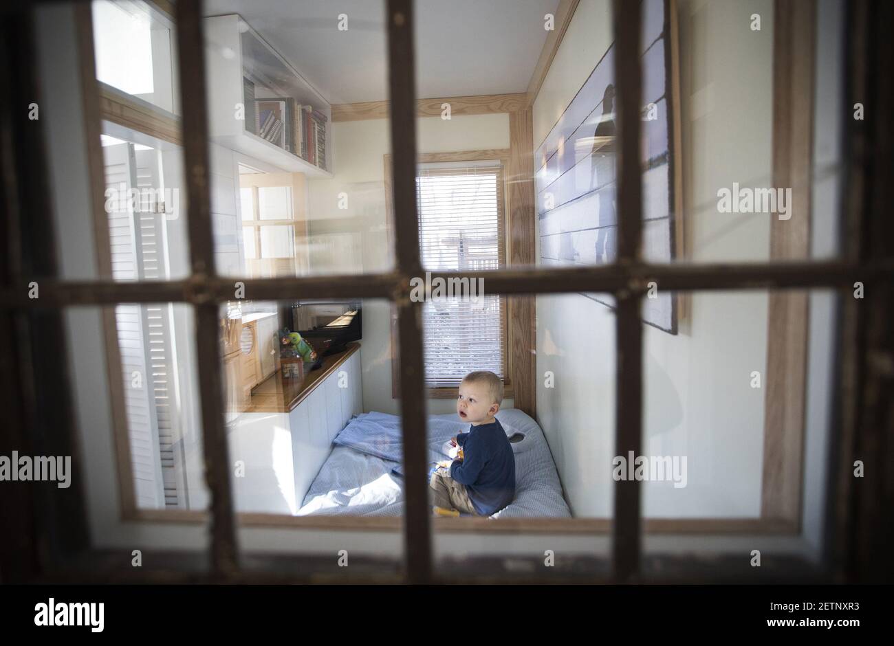 Matthew Mikkelson, 2, plays in his tiny room, seen through an antique ...