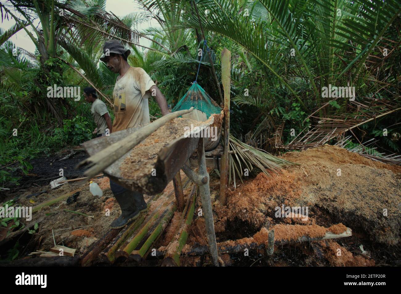 Men at an installation for sago production on the side of Salawai river ...