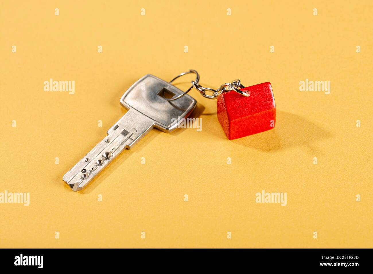 Key with a small red house as a key fob on a yellow background Stock ...