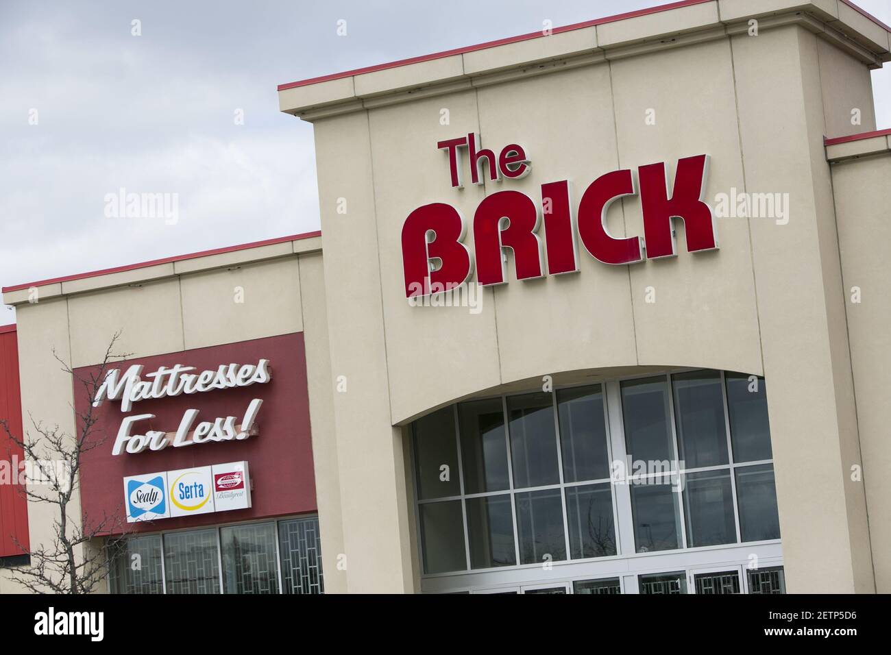 A logo sign outside of a The Brick retail store in Mississauga, Ontario ...