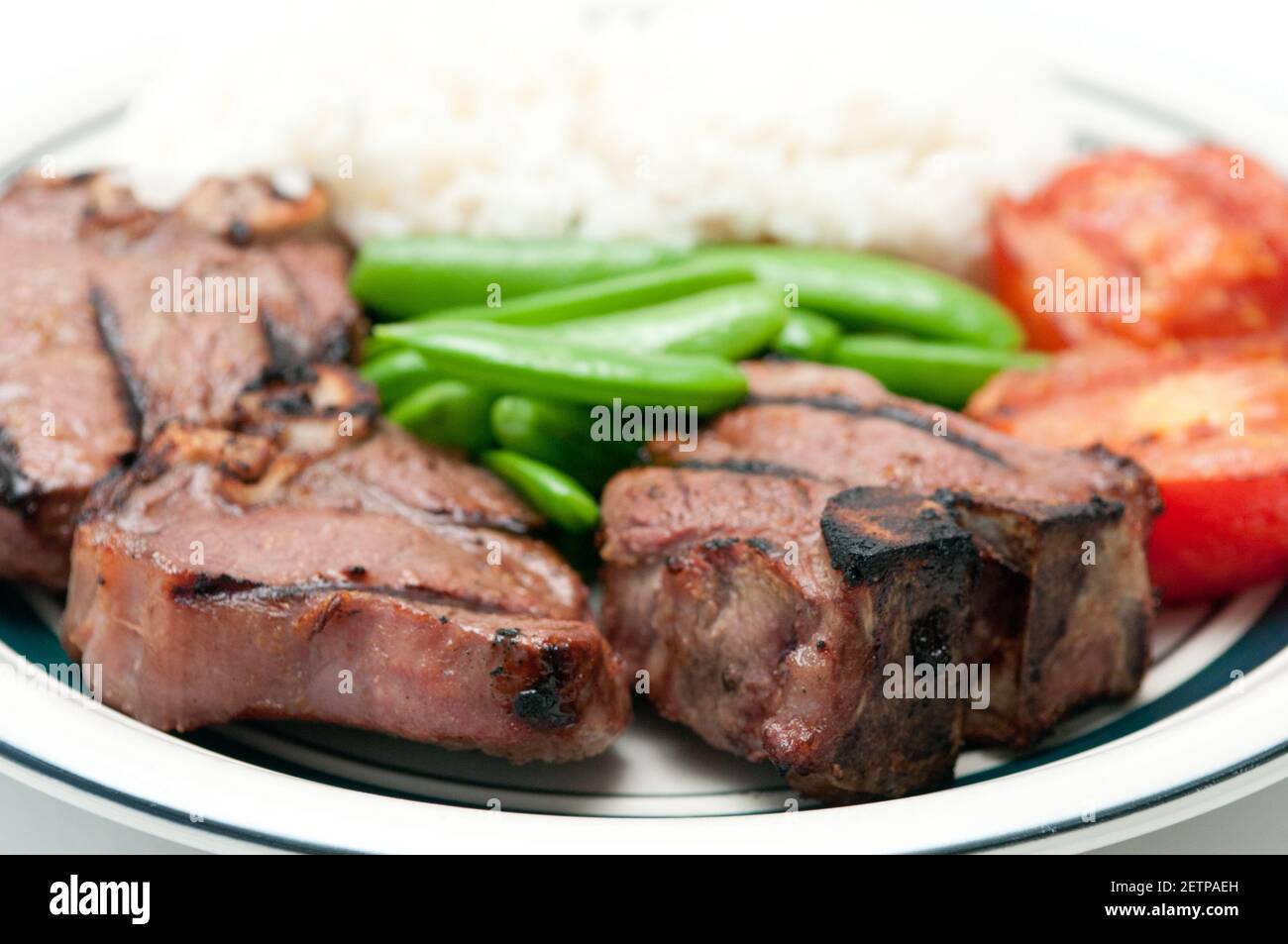 grilled lamb chops with tomato, rice and snap peas Stock Photo - Alamy