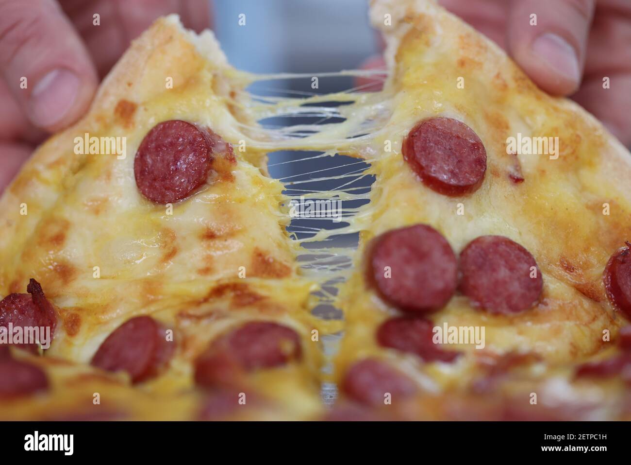 Male hands tearing off slice of hot pizza closeup Stock Photo - Alamy
