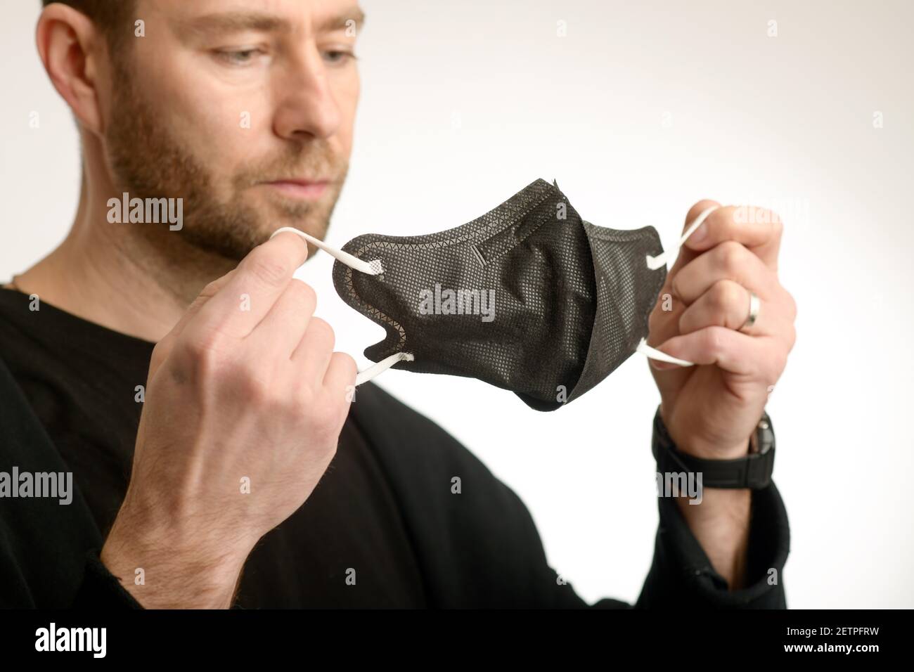 A man wearing a black face mask nano FFP2 Stock Photo - Alamy