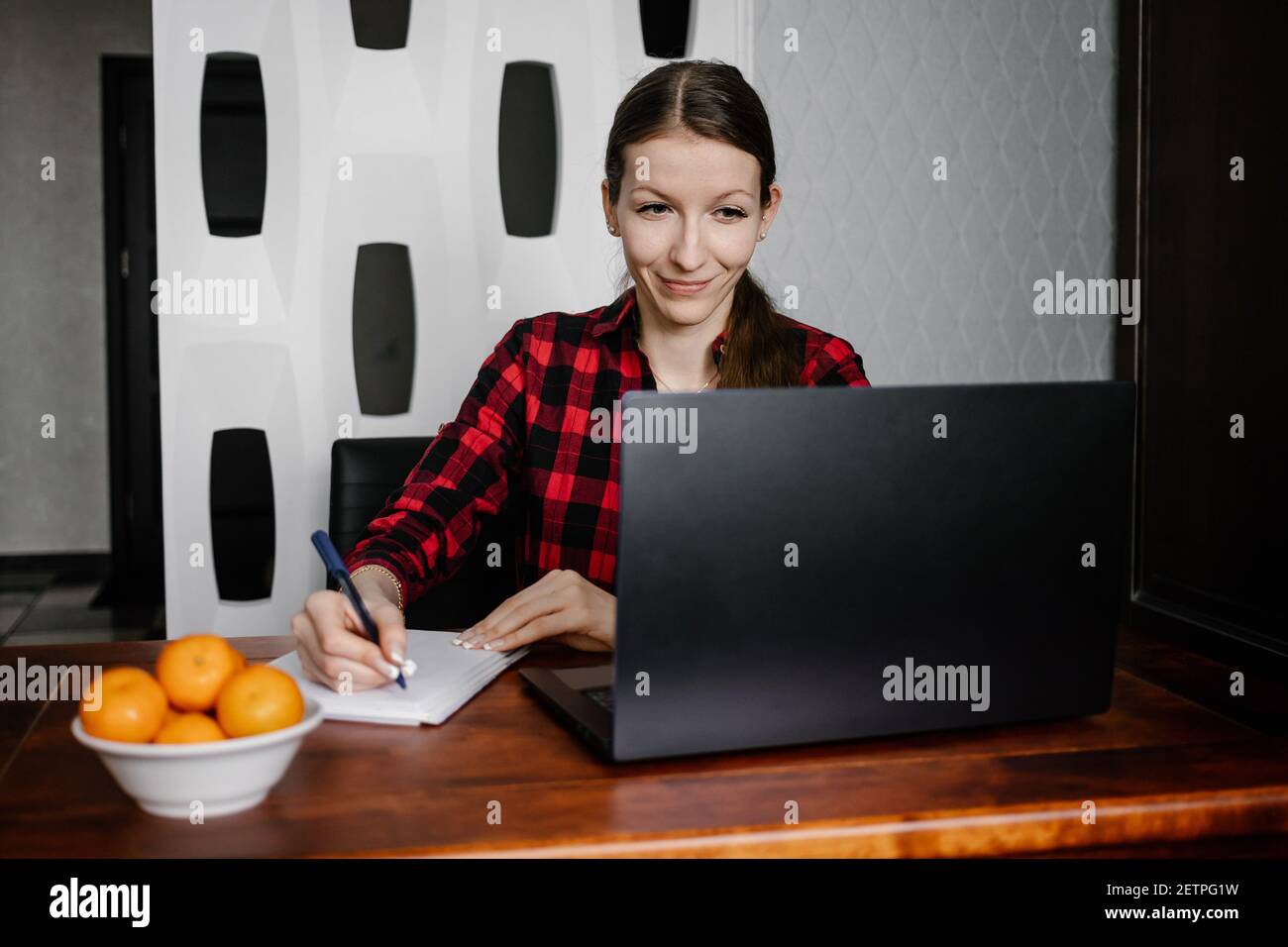 Happy european female student in casual outfit, smiling while using ...