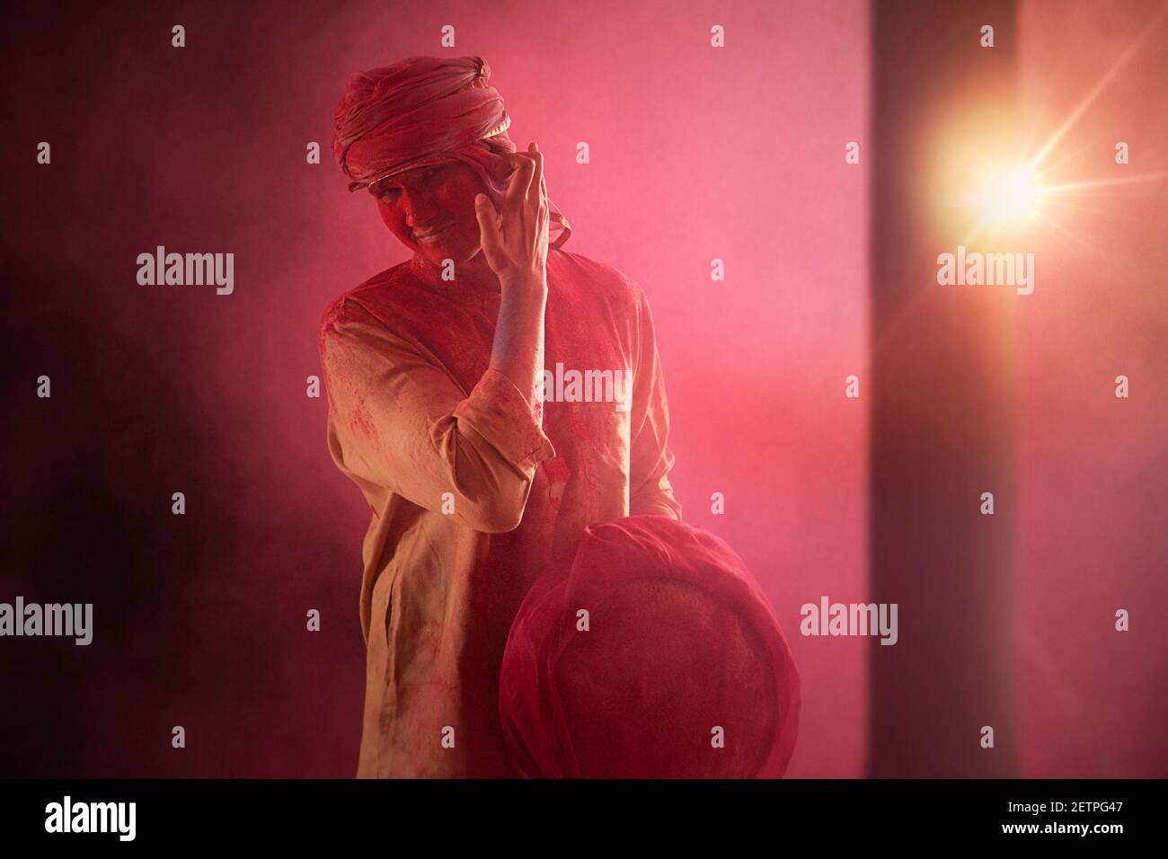 A YOUNG MAN COVERED IN HOLI COLOURS STANDING AND LOOKING AT CAMERA ...