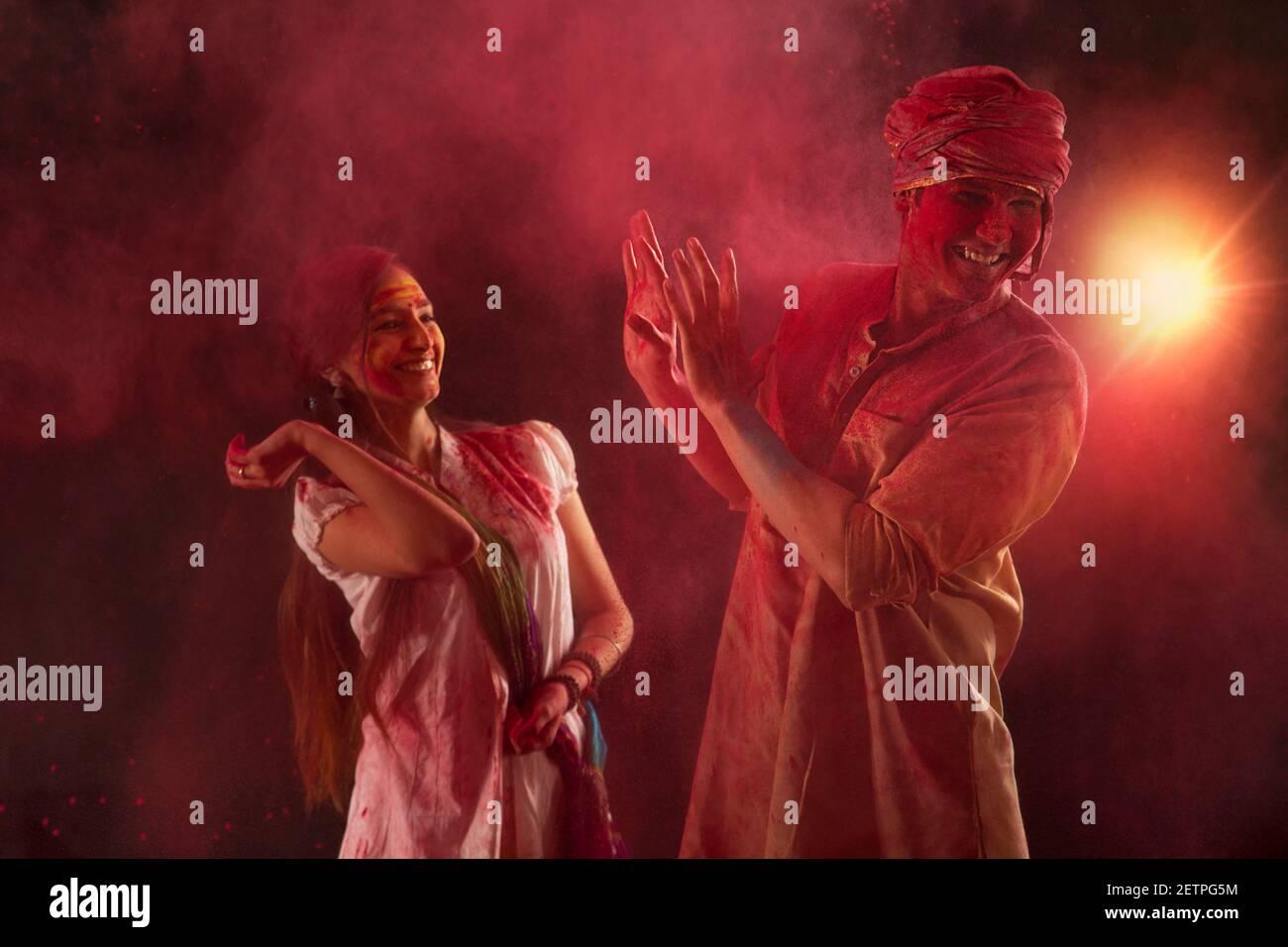 A YOUNG WOMAN HAPPILY THROWING HOLI COLOURS ONTO A YOUNG MAN Stock ...