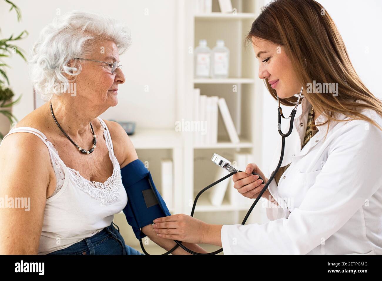 Female doctor checking blood pressure of senior woman in ambulance ...
