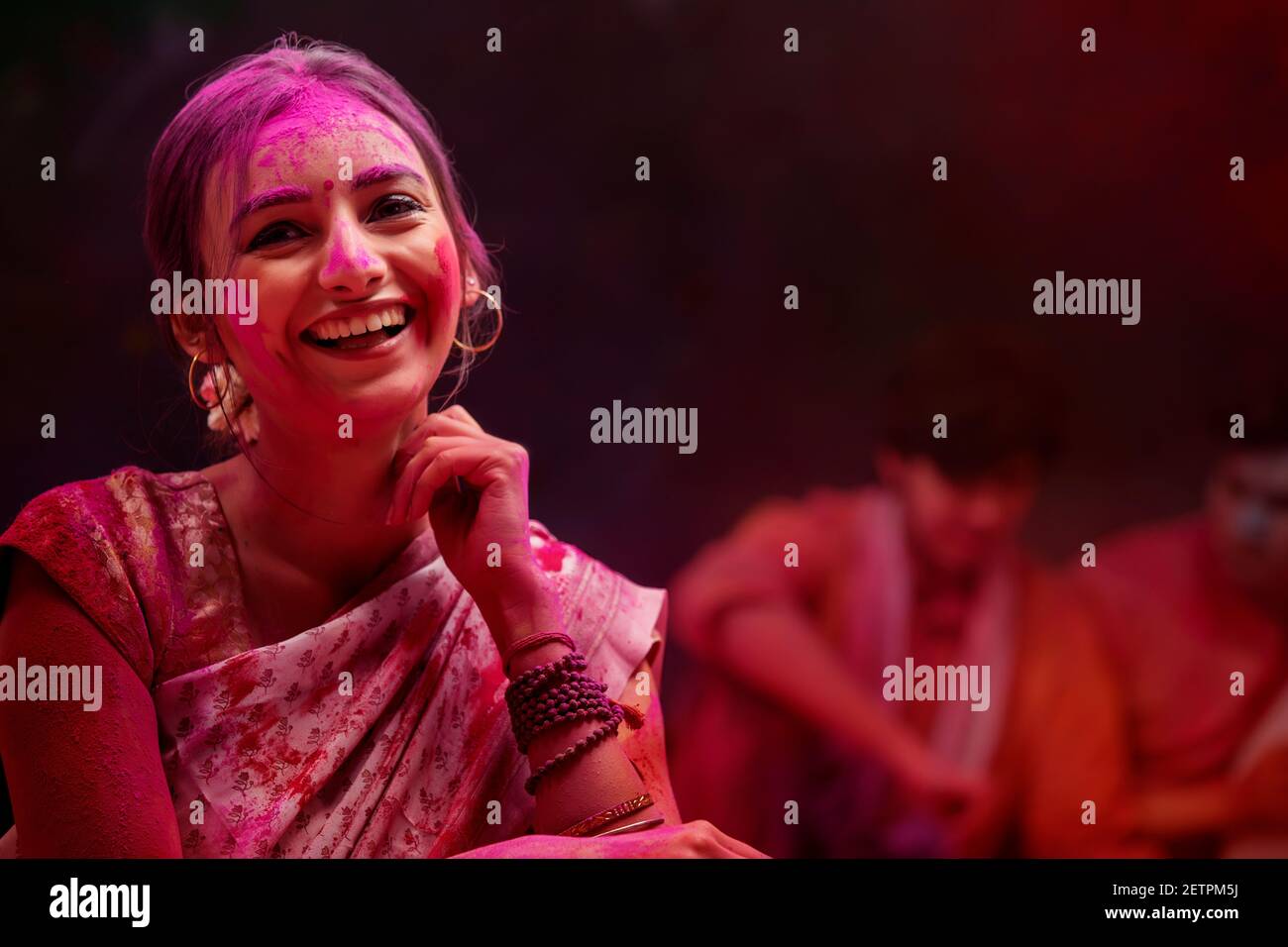 A YOUNG WOMAN IN SAREE LOOKING AT CAMERA AND LAUGHING WHILE CELEBRATING ...