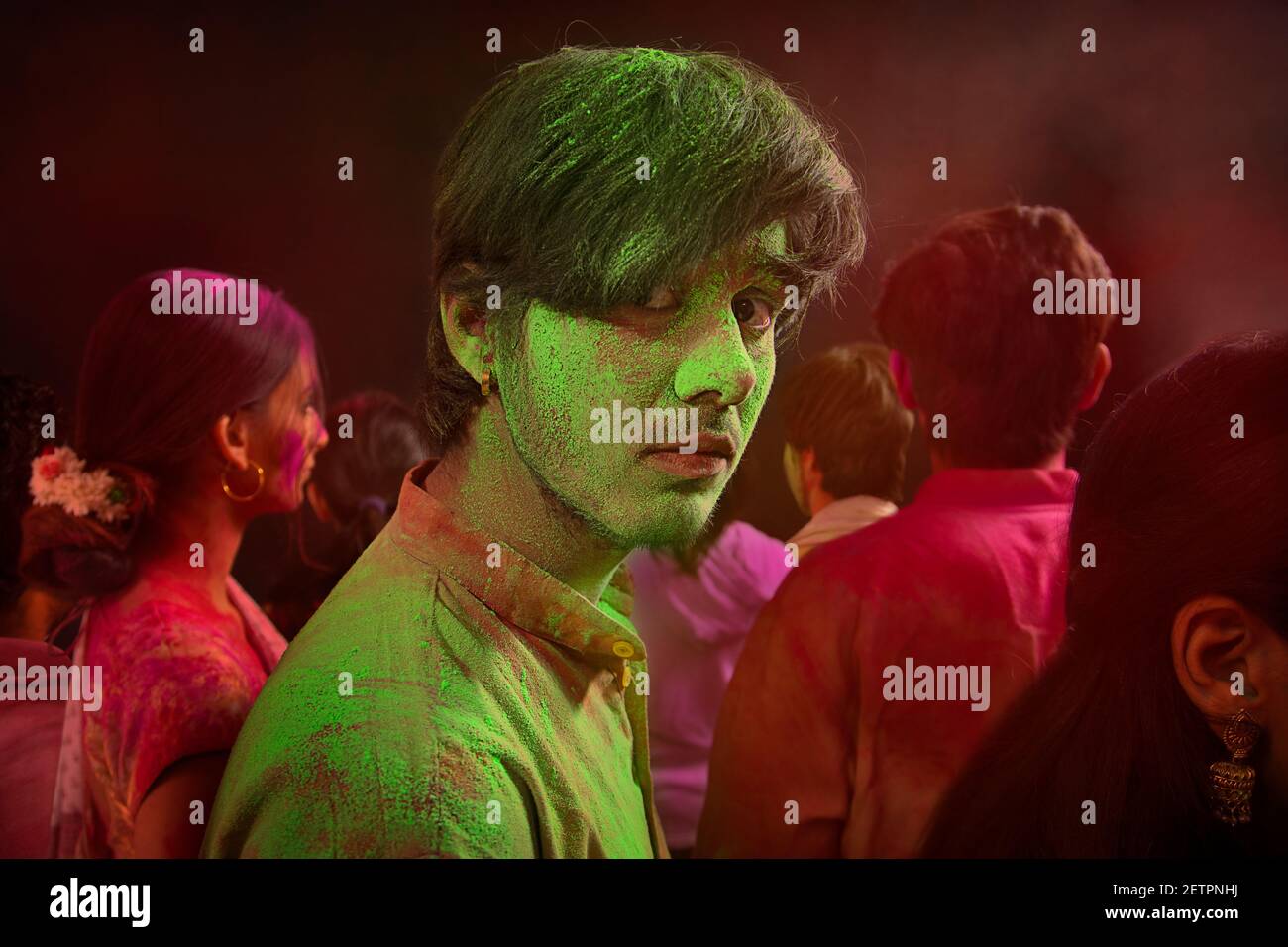 A YOUNG MAN WITH GULAL ALL OVER HIS FACE TURNING AROUND AND SERIOUSLY ...