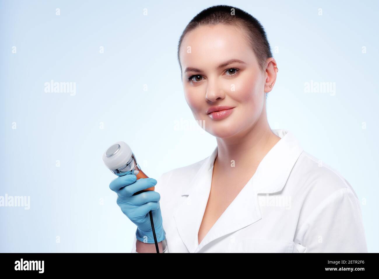 Portrait of a woman dermatologist holding cosmetic device attachment ...