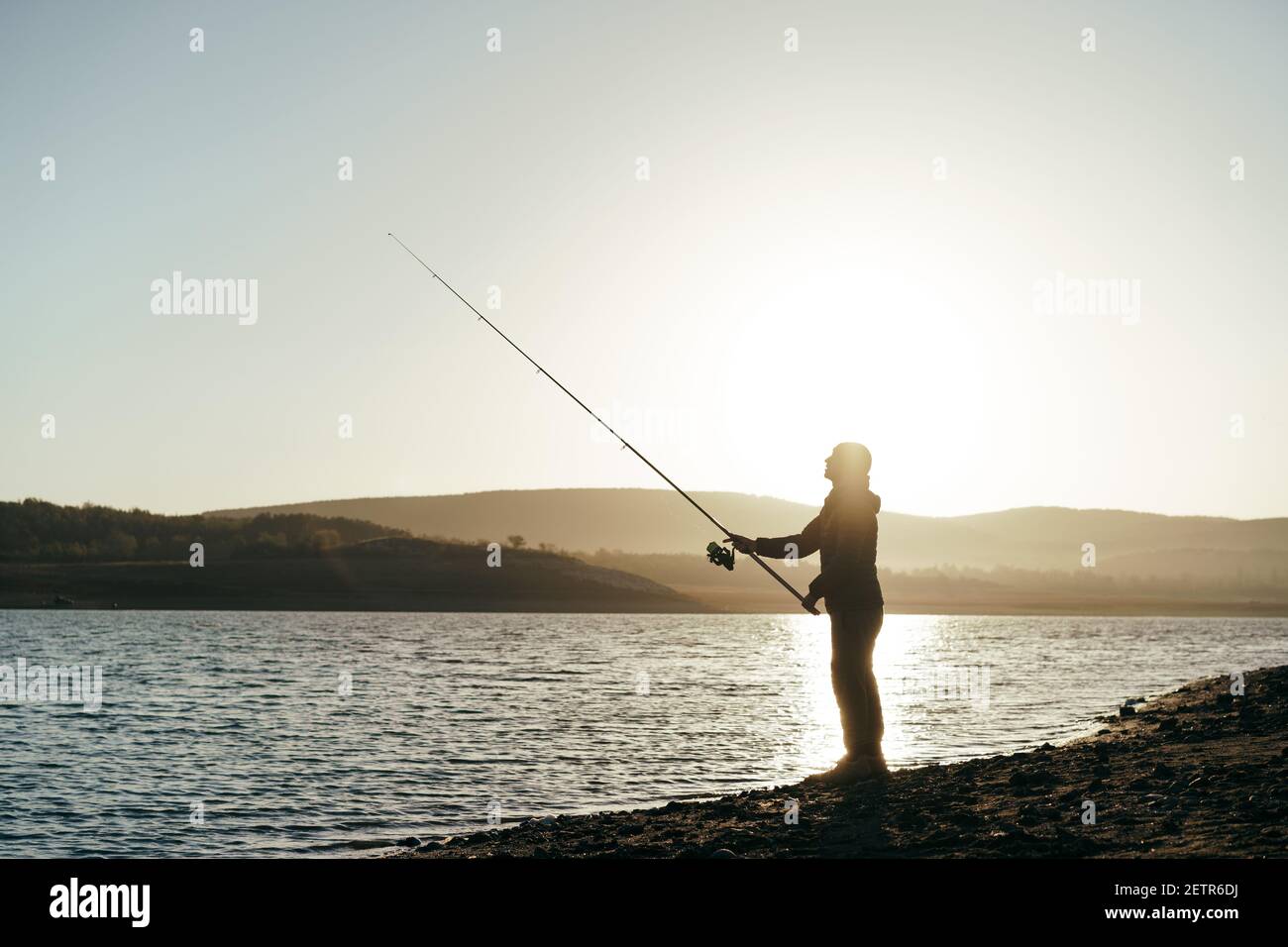 Fisherman with rod fishing on the lake Stock Photo - Alamy